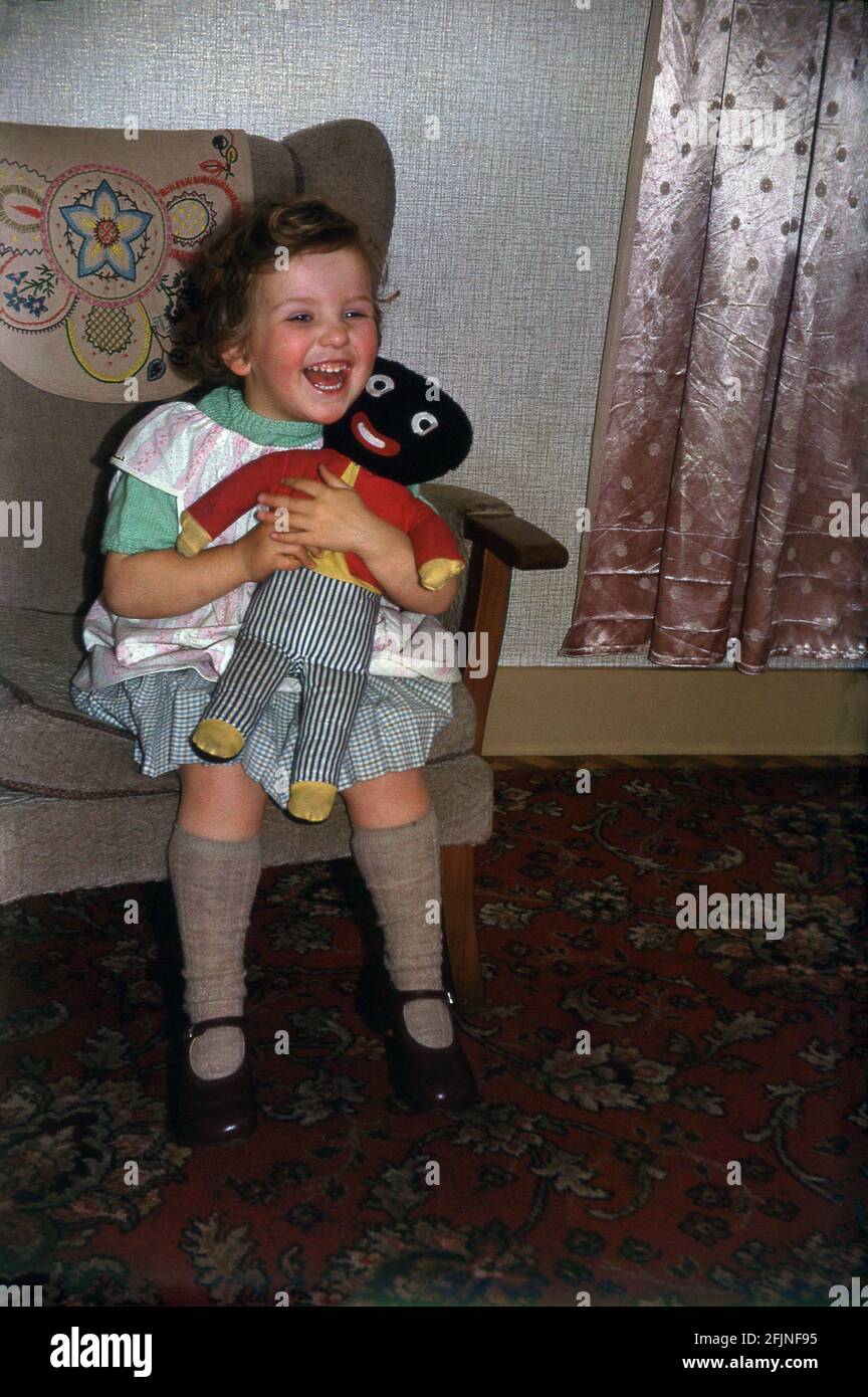 1960s, historical picture of a happy little girl sitting on a lounge ...