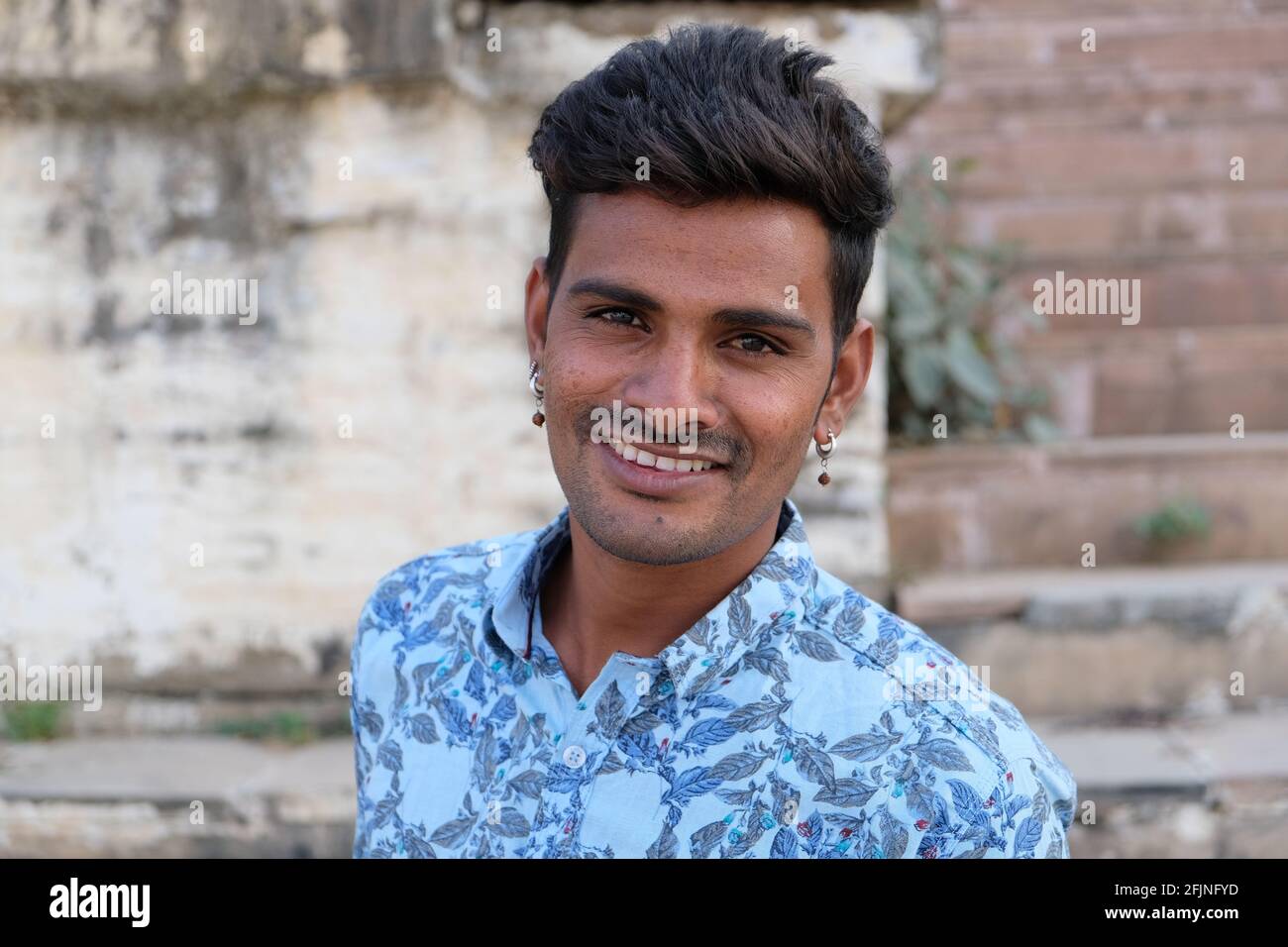 A portrait of a young smiling Indian male standing outdoors Stock Photo ...