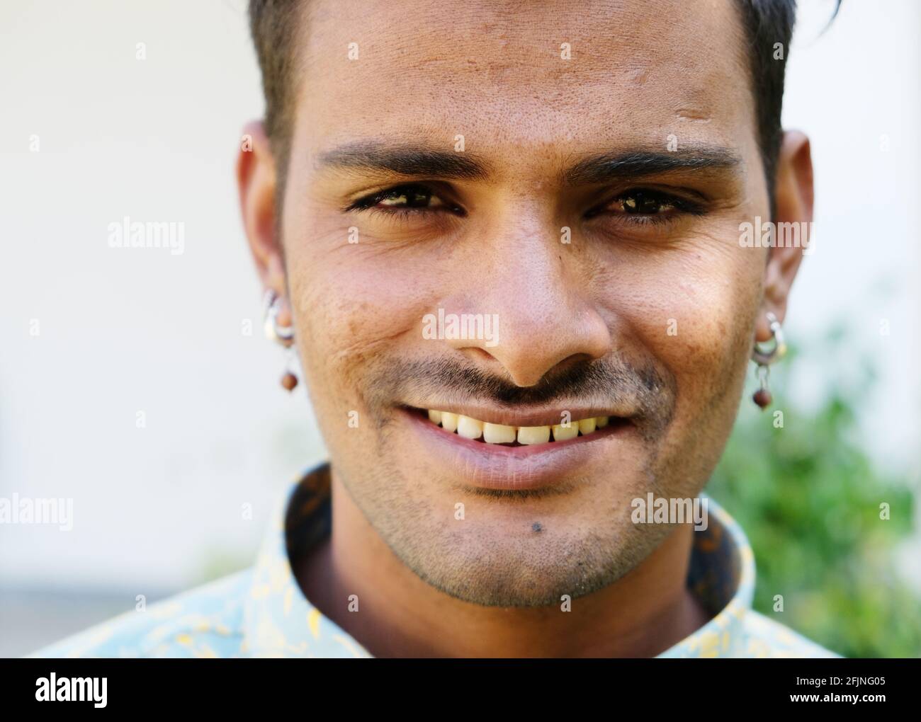 A portrait of a young smiling Indian male standing outdoors Stock Photo ...