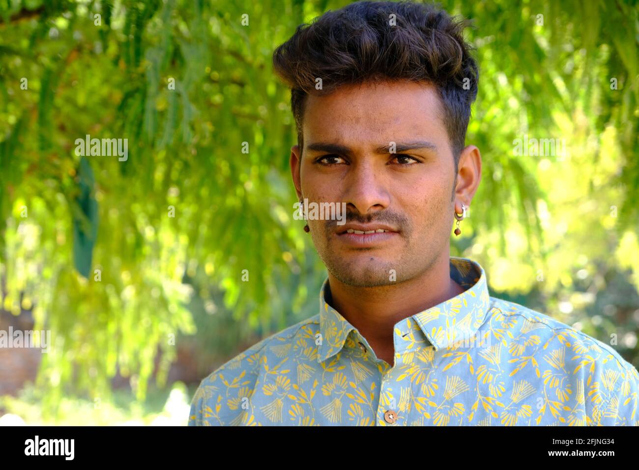 A portrait of a young handsome Indian male standing in a park Stock ...