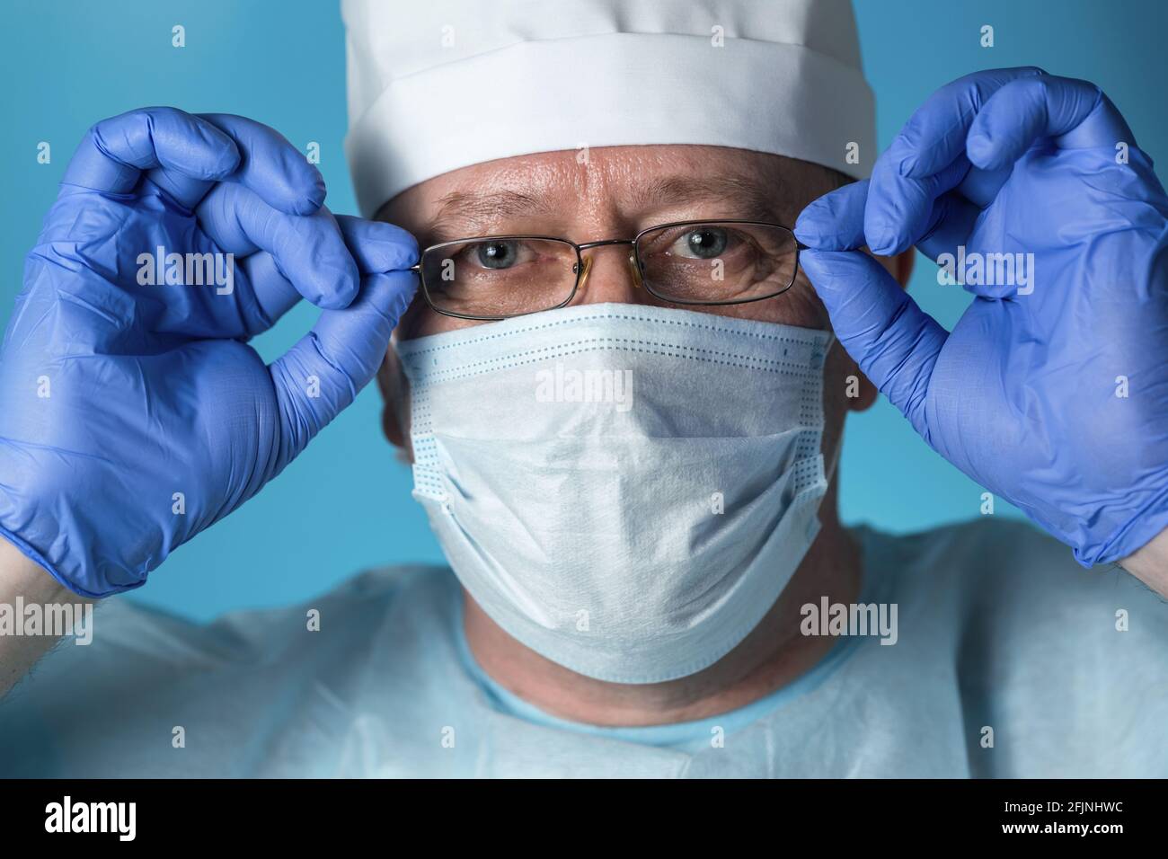 A doctor in medical clothing: a cap, gloves, dressing gown and mask ...