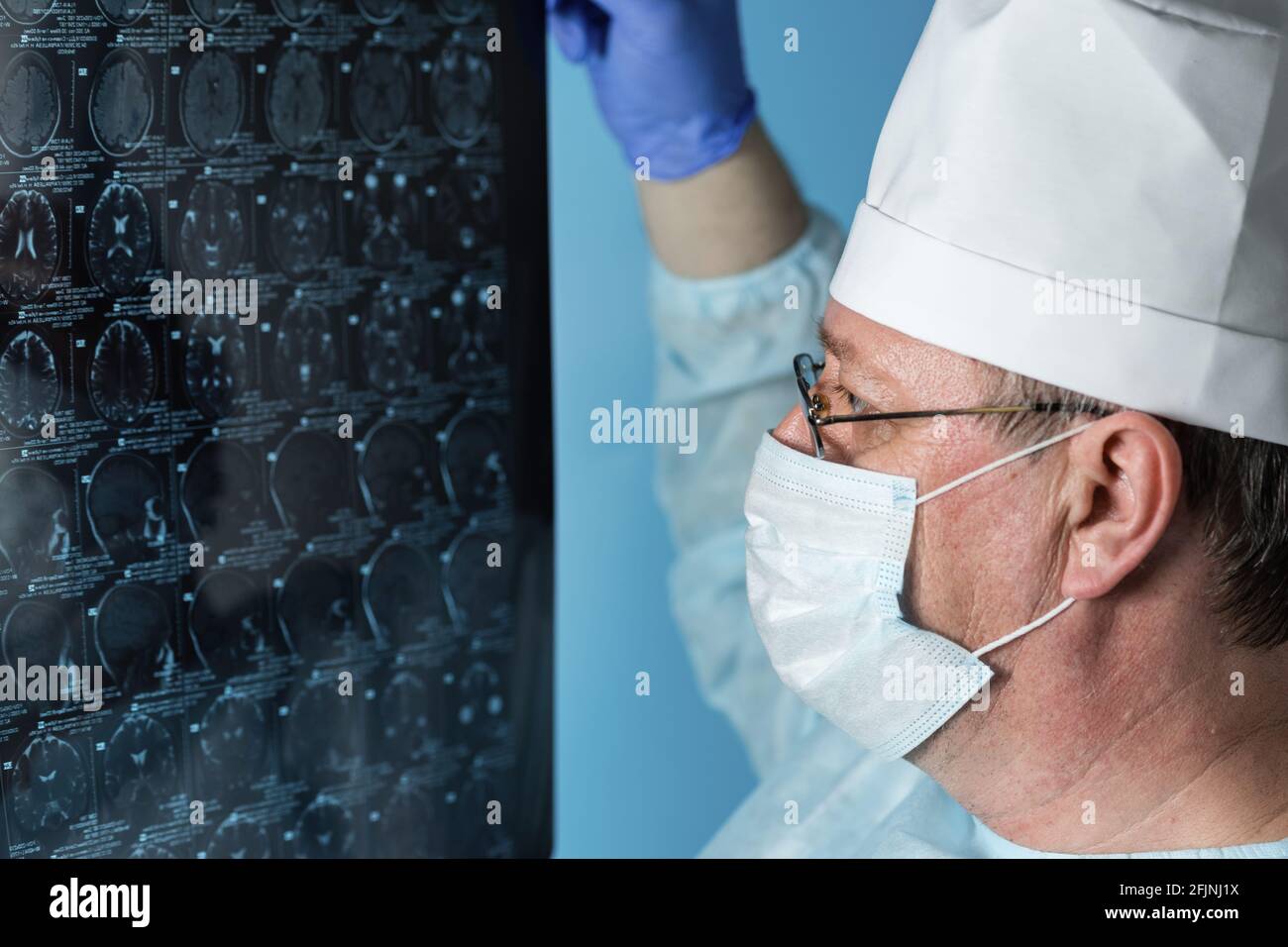 A male doctor in medical clothing: a cap, gloves, dressing gown and ...