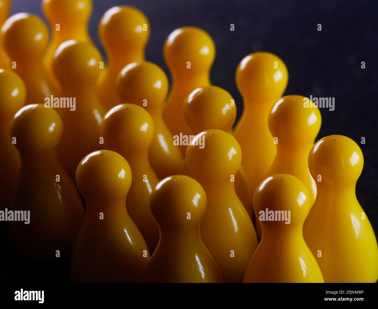 A studio shot of yellow monopoly plastic chips on black background ...