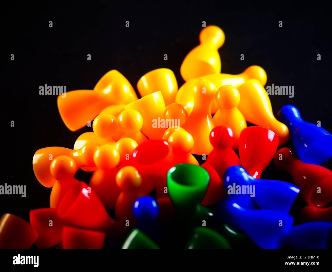 A studio shot of colorful monopoly plastic chips on black background ...