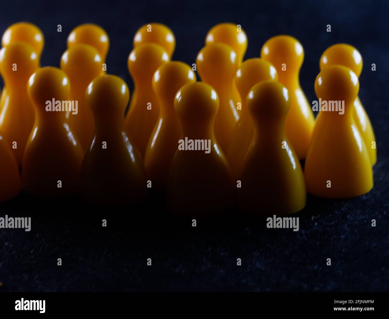 A studio shot of yellow monopoly plastic chips on black background ...