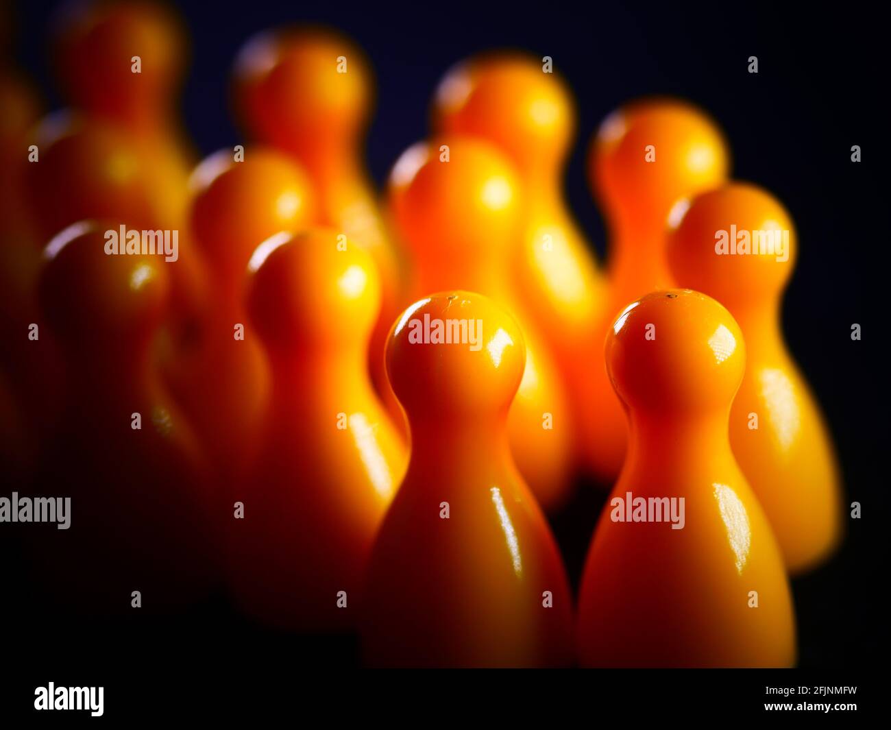 A studio shot of yellow monopoly plastic chips on black background ...