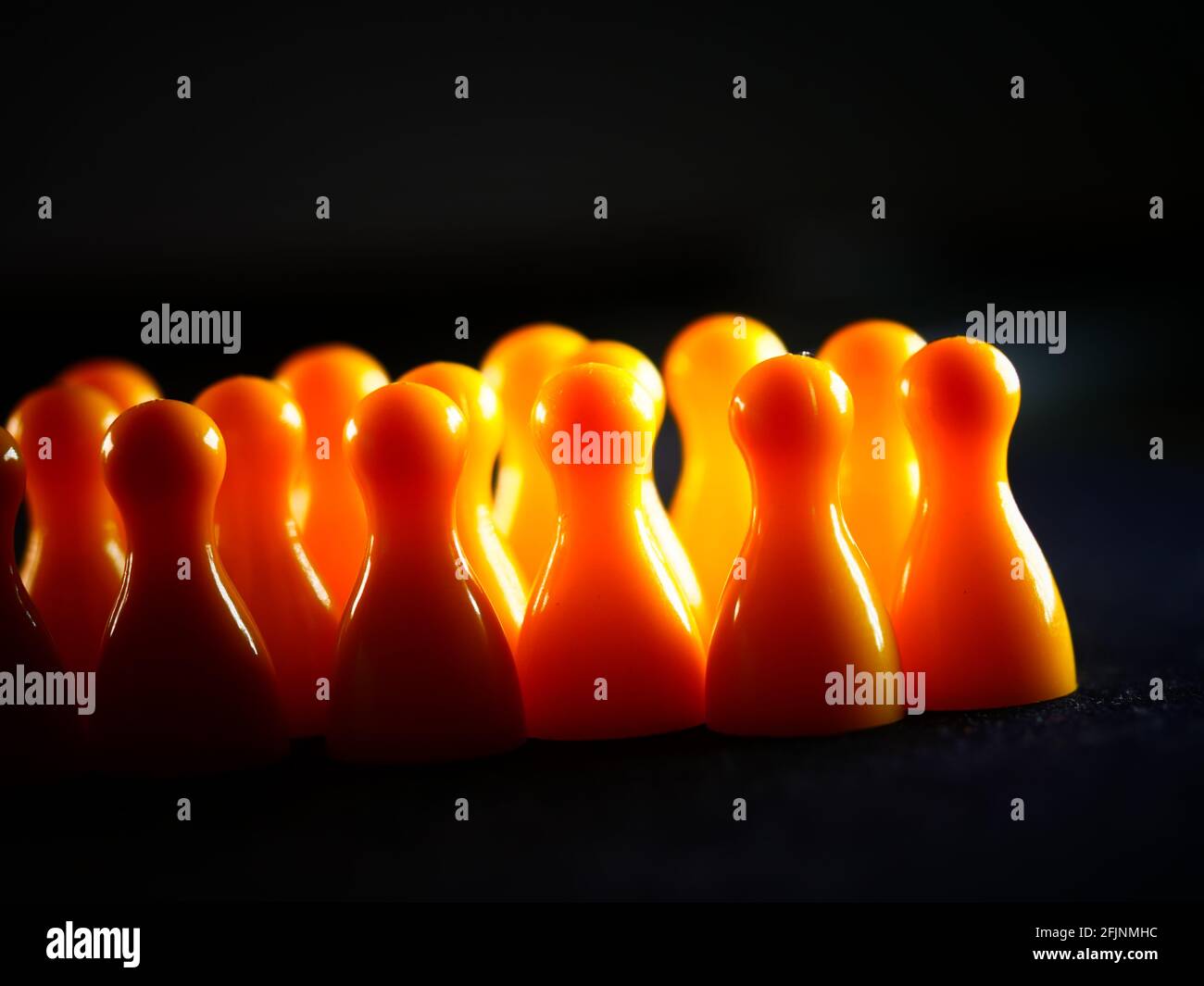 A studio shot of yellow monopoly plastic chips on black background ...