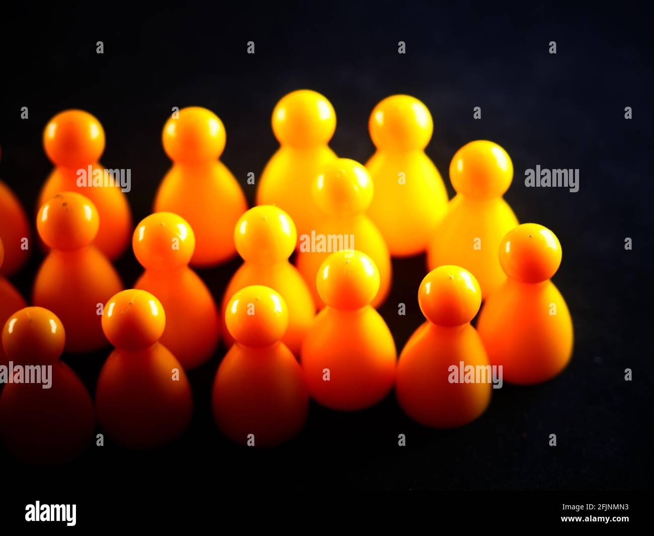 A studio shot of yellow monopoly plastic chips on black background ...