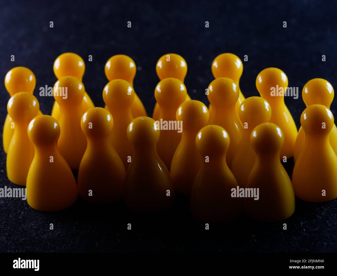 A studio shot of yellow monopoly plastic chips on black background ...
