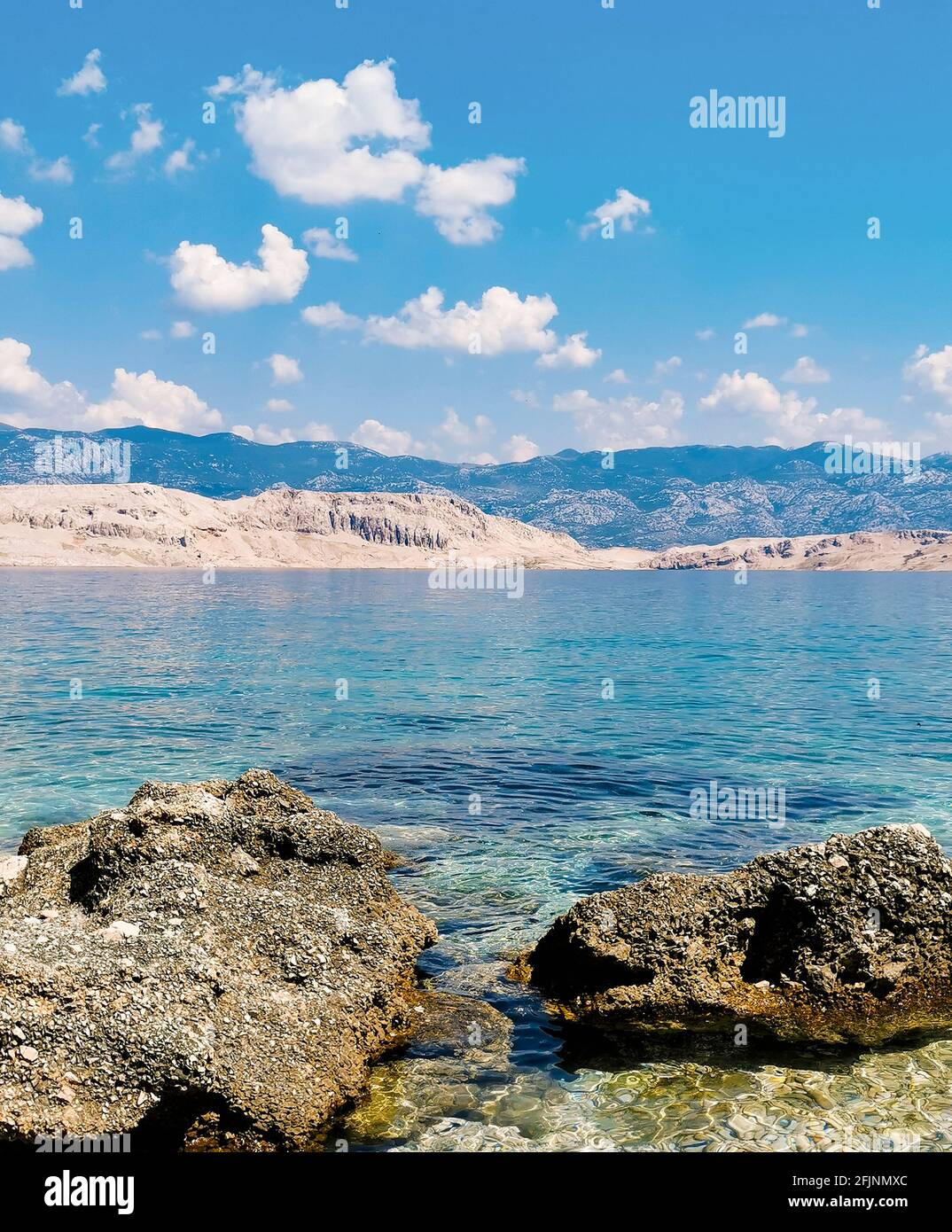 A breathtaking view of a rock lakeshore with transparent blue water ...