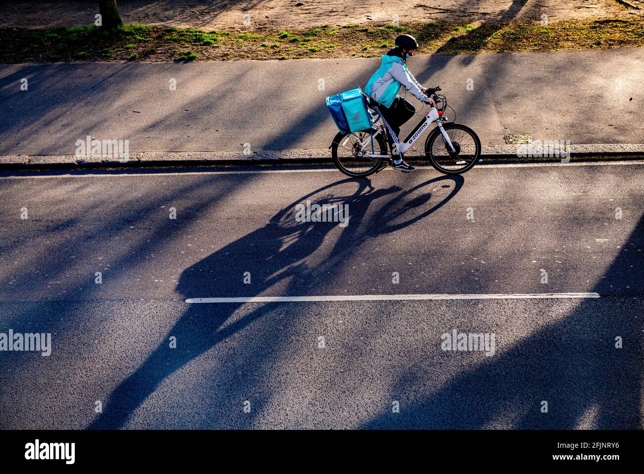 A cyclist casts a long shadow in the later afternoon sunshine Stock ...
