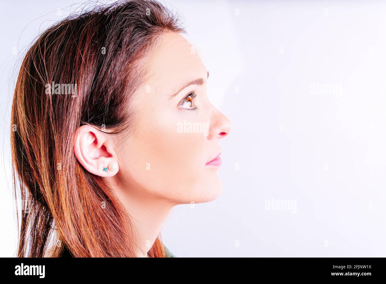 Beautiful young adult woman in profile looking up with copyspace on ...