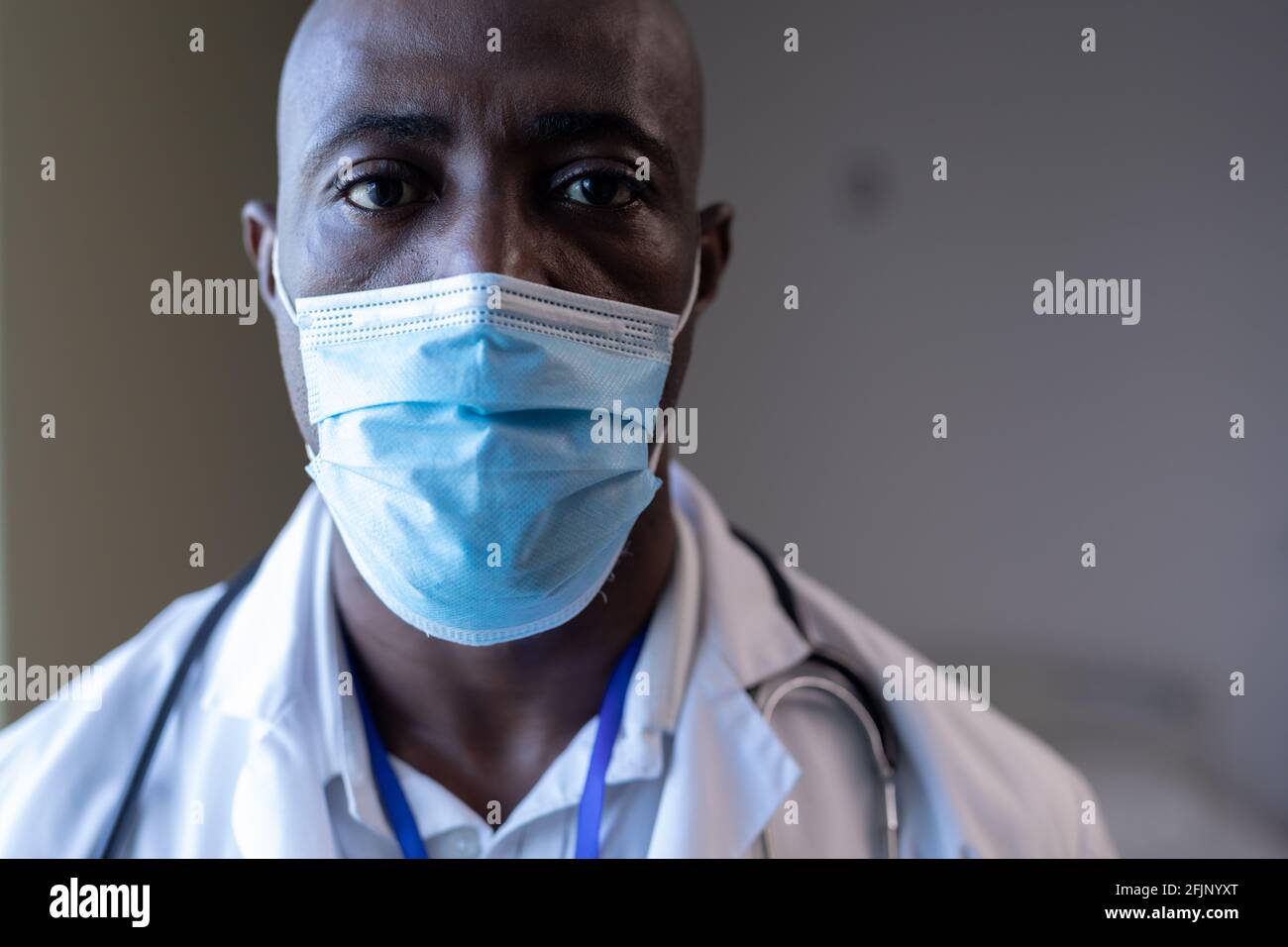 Portrait of african american male doctor in hospital wearing face mask ...