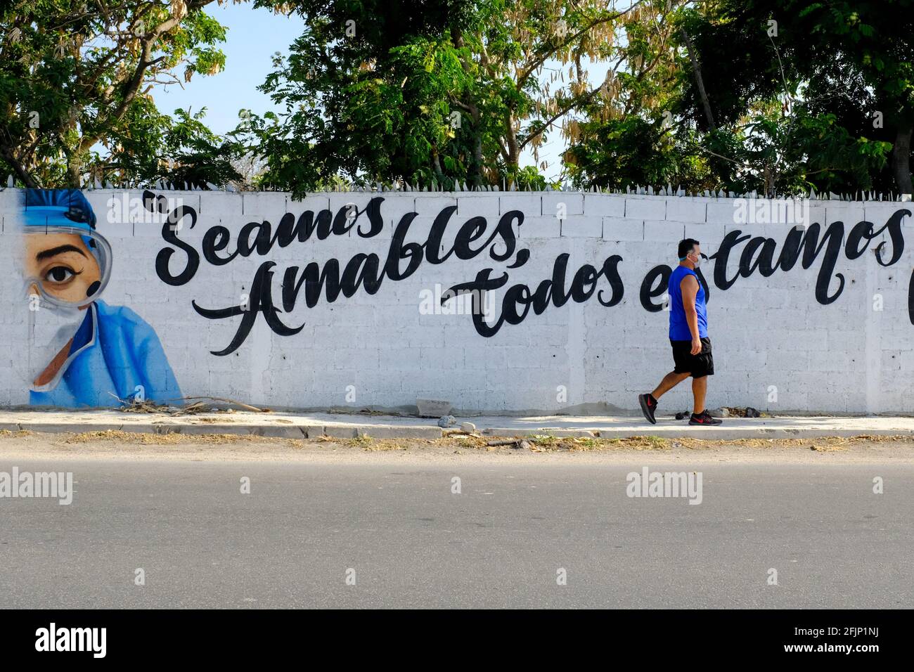 Man passing in front of a mural portraying the Covid-19 first ...