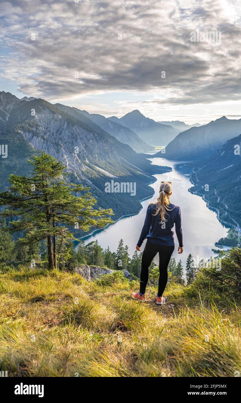 Hiker looking at Plansee, mountains with lake, Ammergau Alps, district ...