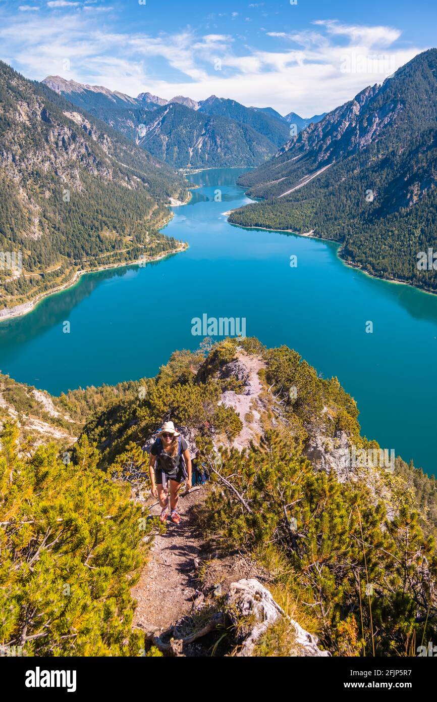 Hiker walking at Plansee, mountains with lake, Ammergau Alps, district ...