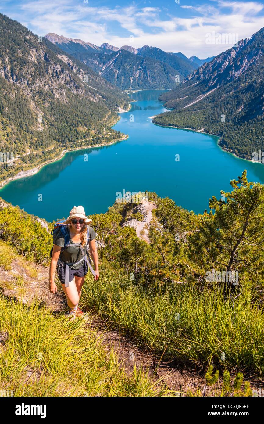 Hiker walking at Plansee, mountains with lake, Ammergau Alps, district ...