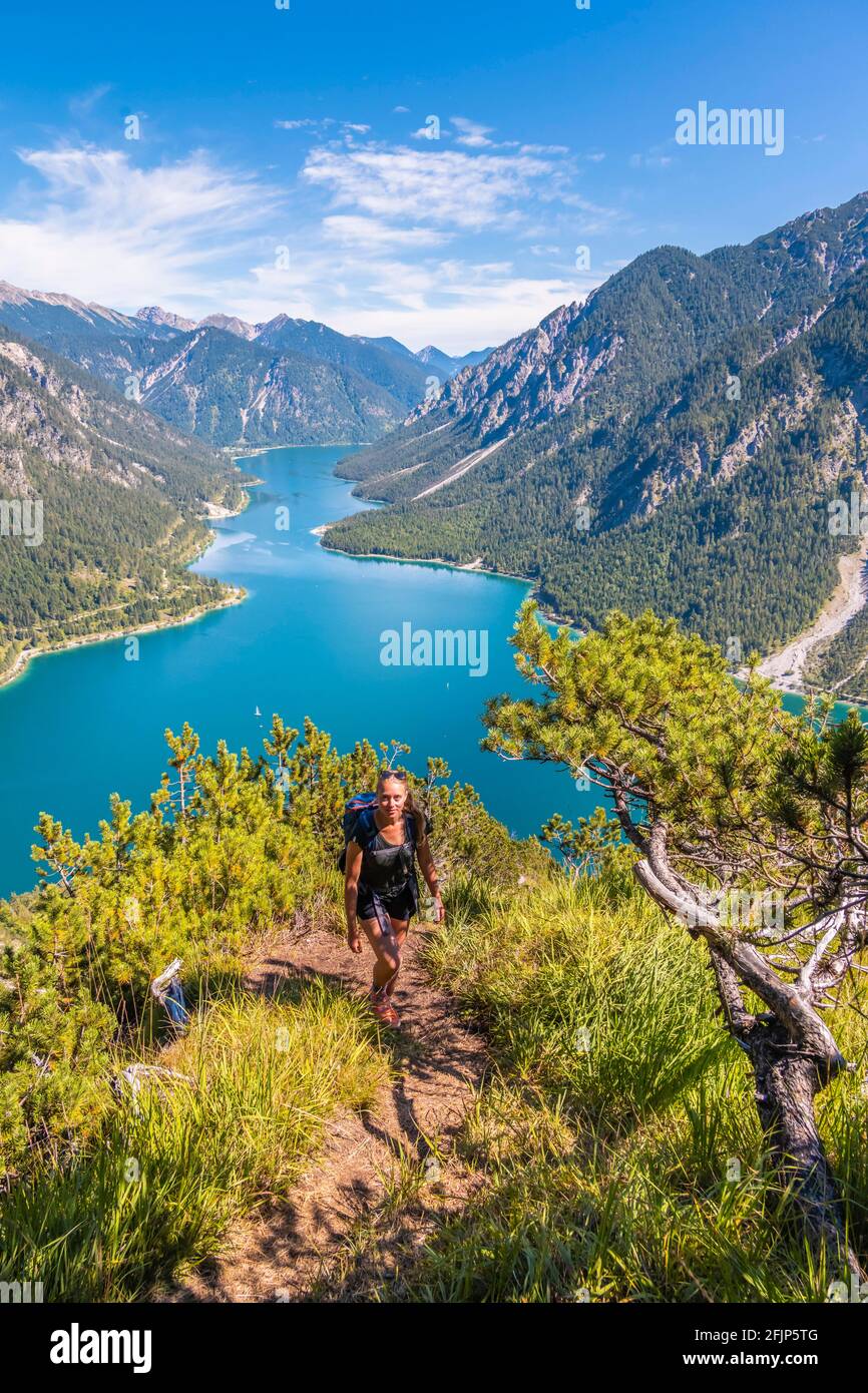 Hiker walking at Plansee, mountains with lake, Ammergau Alps, district ...