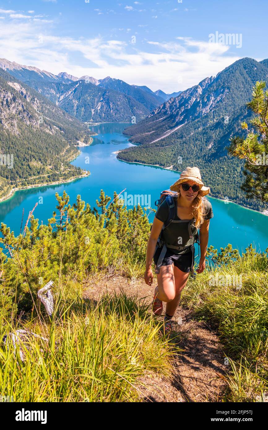 Hiker walking at Plansee, mountains with lake, Ammergau Alps, district ...