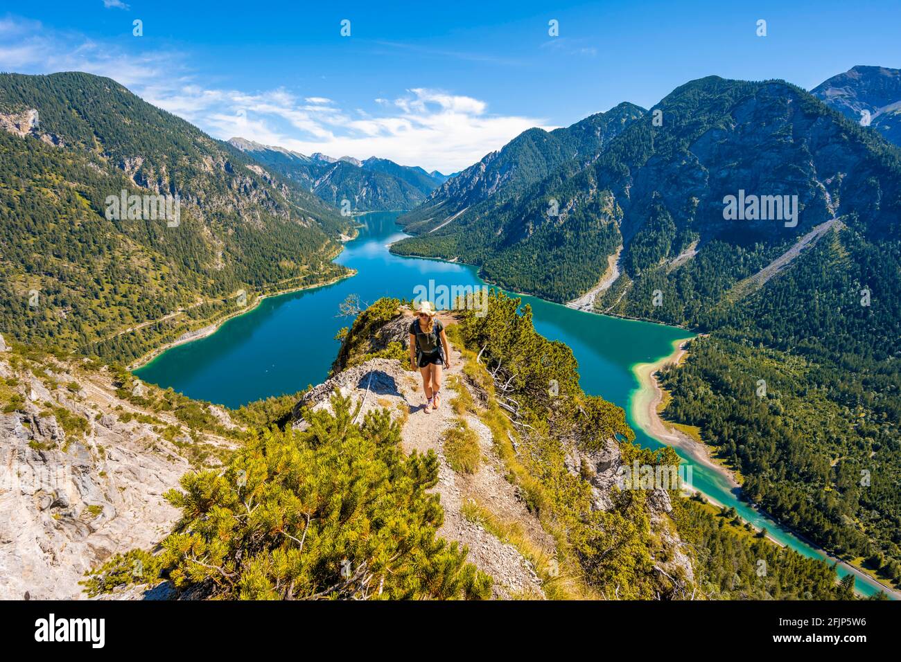 Hiker walking at Plansee, mountains with lake, Ammergau Alps, district ...