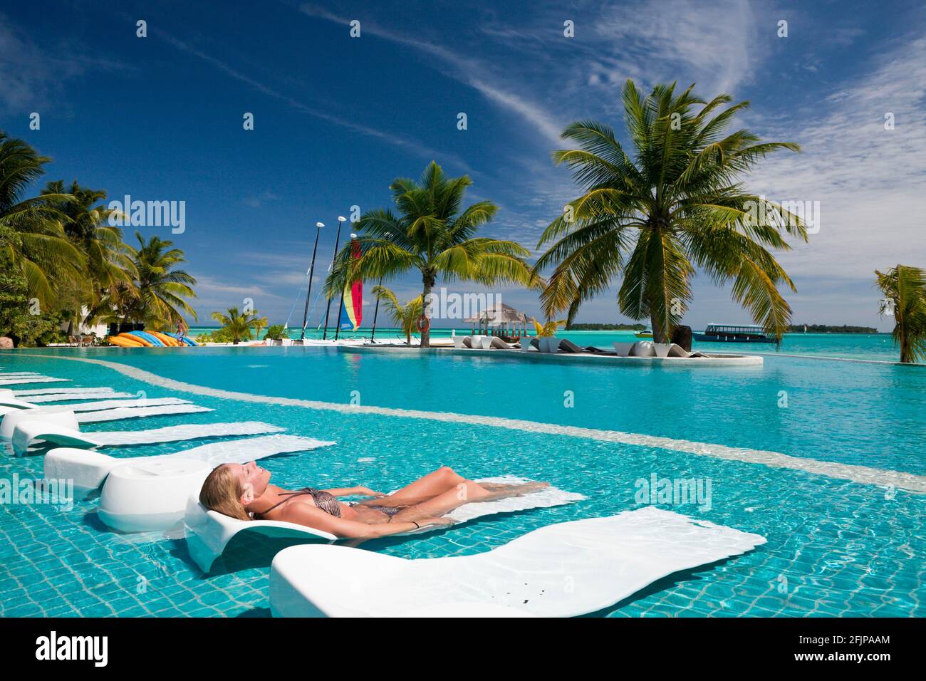 Woman sunbathing at pool, Kandooma Island, South Male Atoll, swimming ...