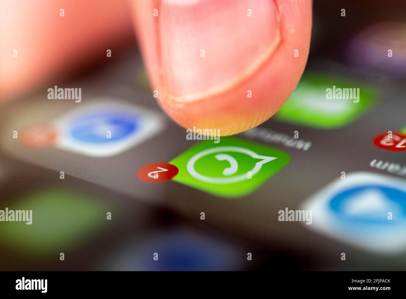 Finger tapping on screen with app icons of messenger services and ...