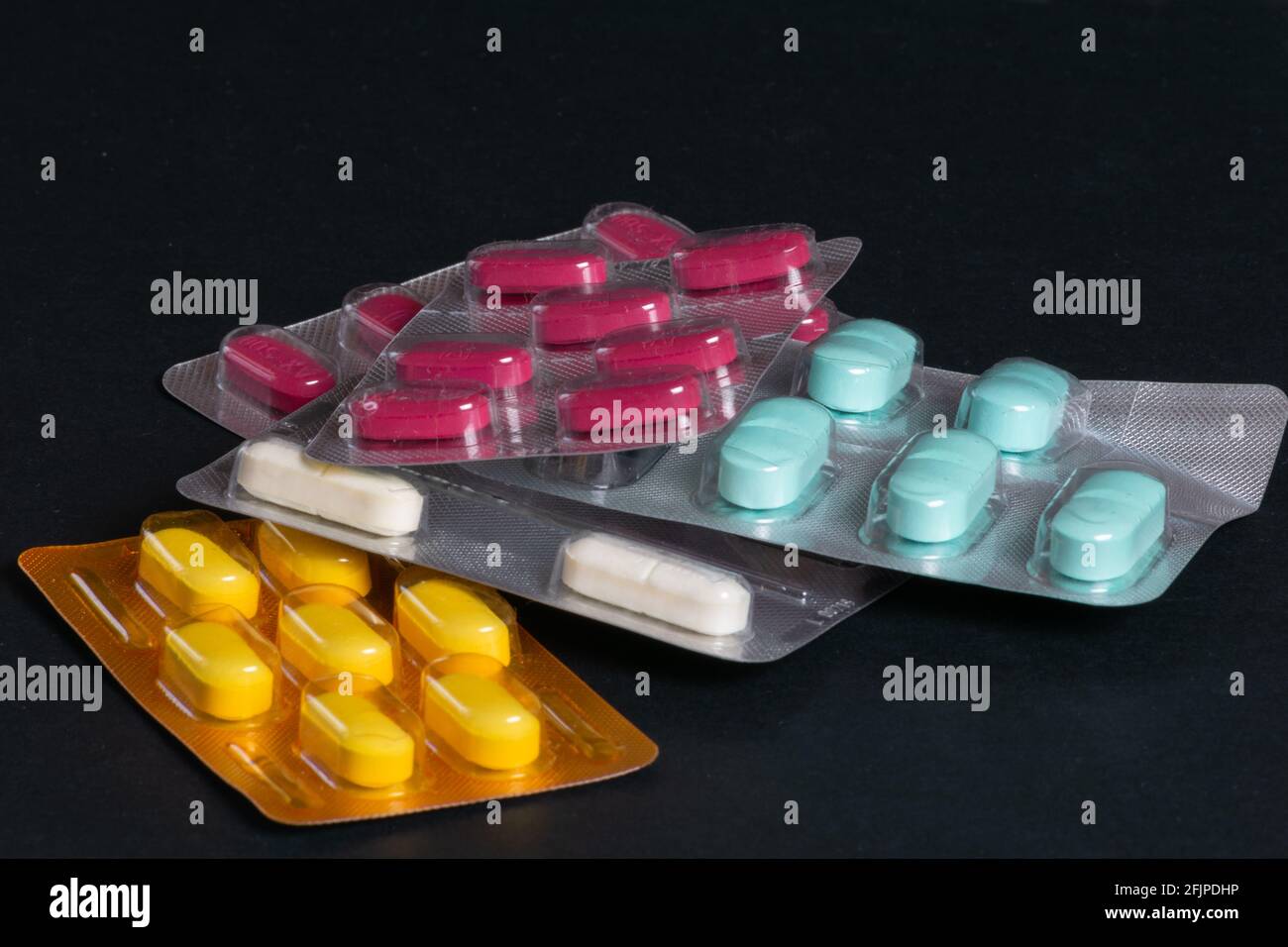 Drug tablets of different types and colors on black background Stock ...