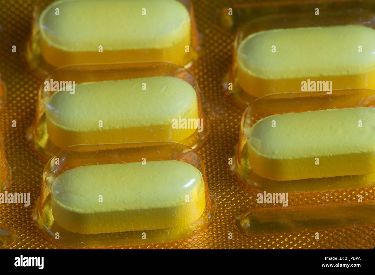 Drug tablets in yellow color macro photography Stock Photo - Alamy