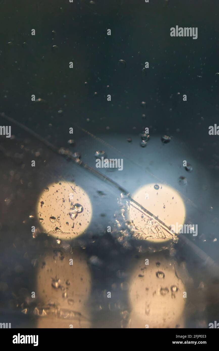 blurry headlights and reflection through streaky car window Stock Photo ...
