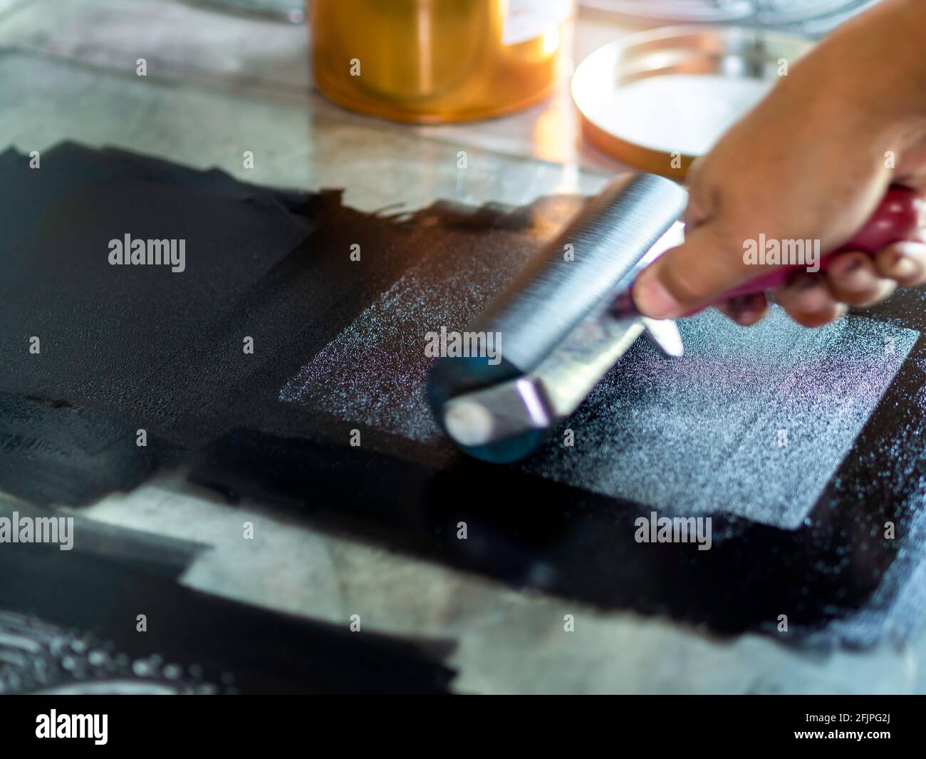 Motion blur of the artist hand, printmaker rolling a printmaking roller ...