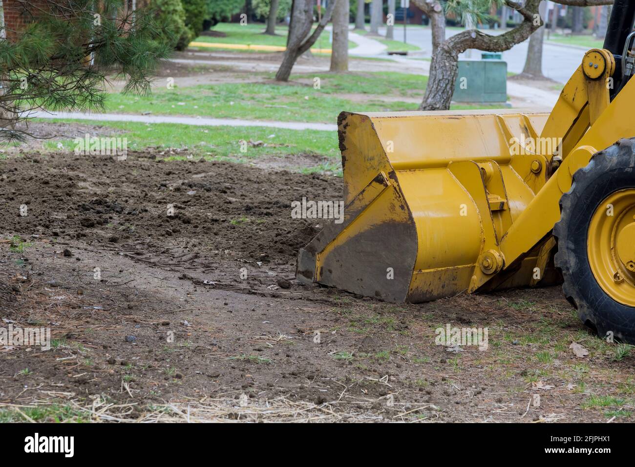 Small tractor digging land working with land Stock Photo - Alamy