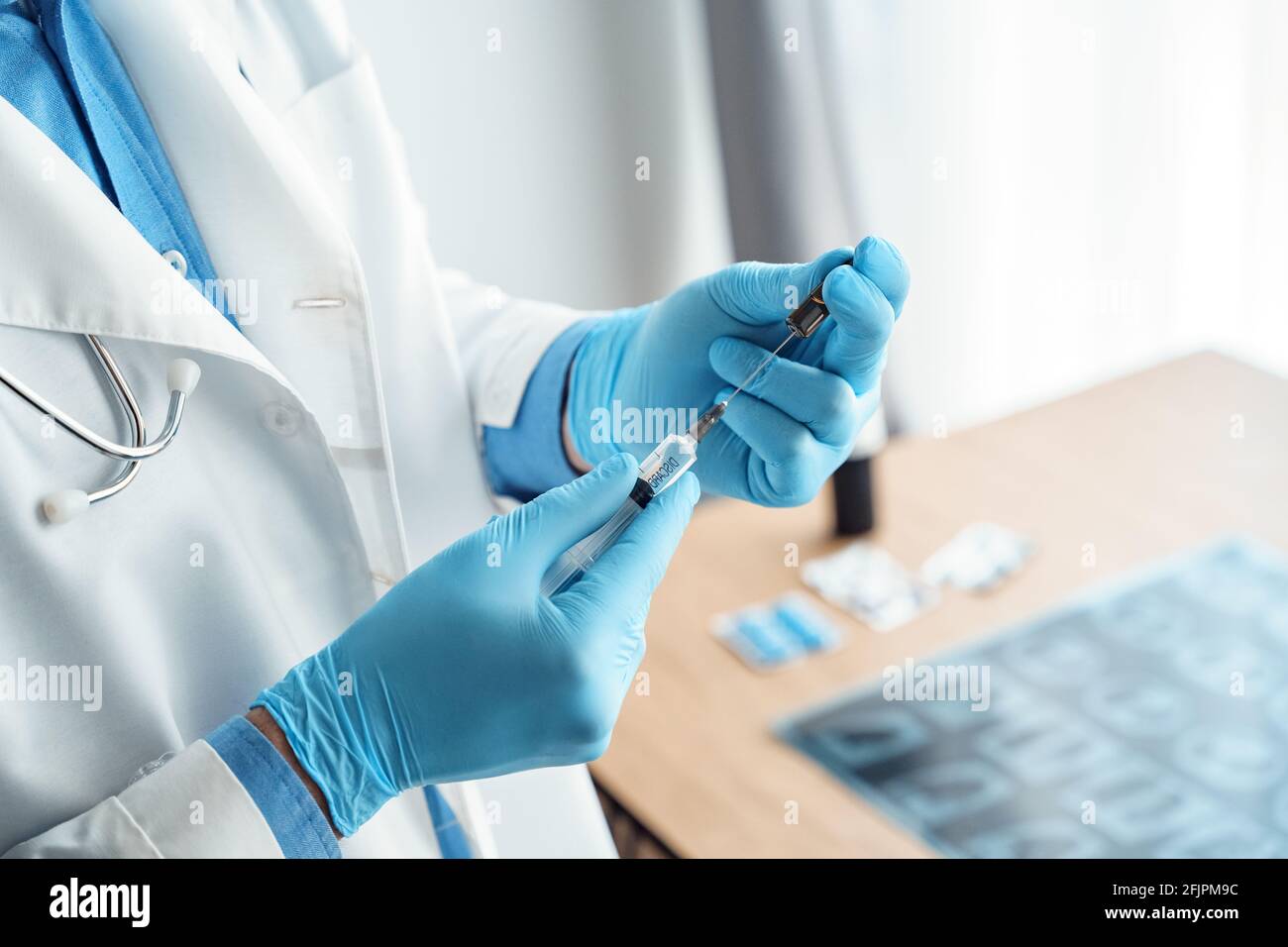 Closeup doctor hand in medical gloves filling syringe with drug dose ...