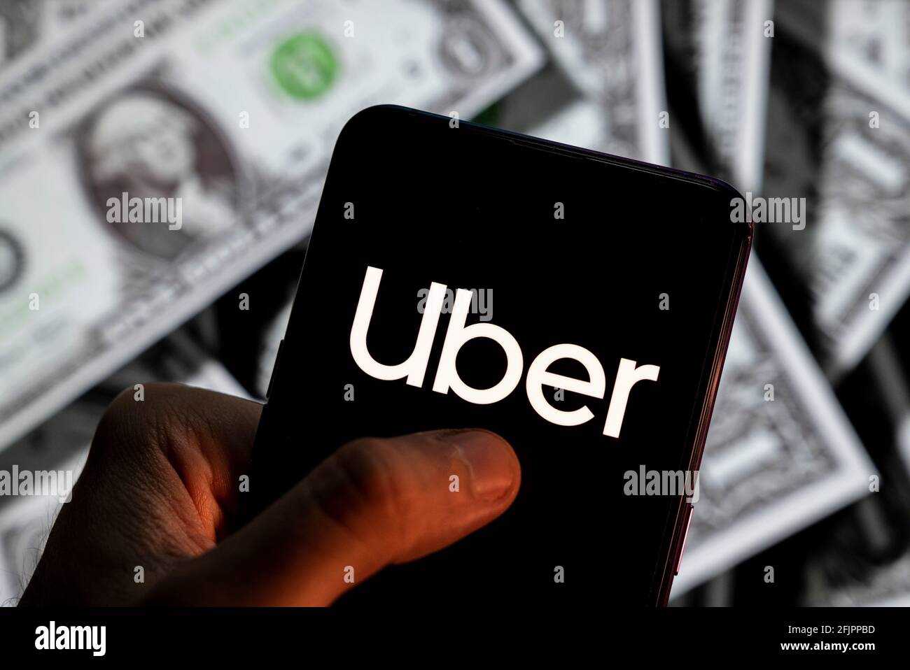 In this photo illustration, an Uber logo seen displayed on a smartphone ...