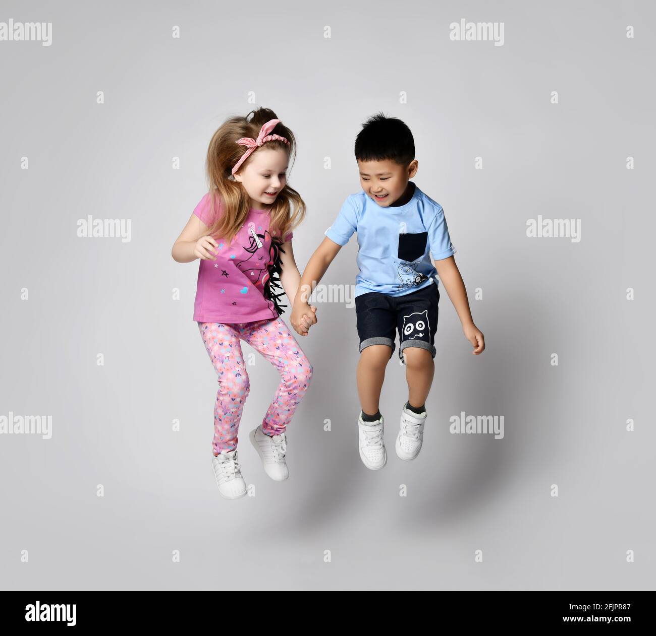 Two active happy kids friends Asian boy and Caucasian girl in summer ...