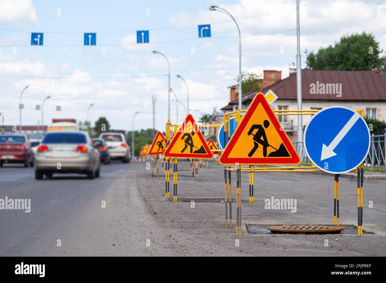 Asphalt road repairs, yellow warning triangle signs about road works ...