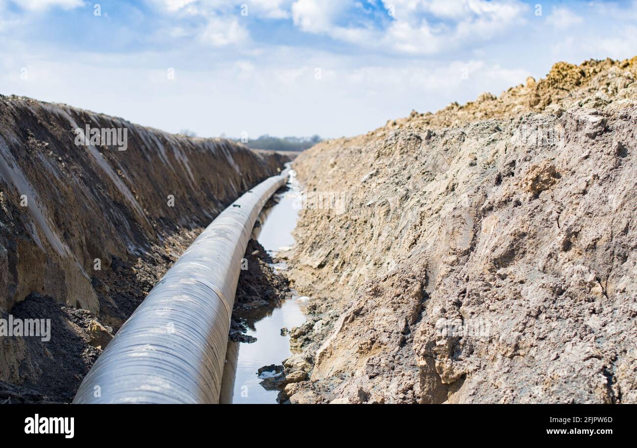 Natural gas pipeline construction work. A dug trench in the ground for ...
