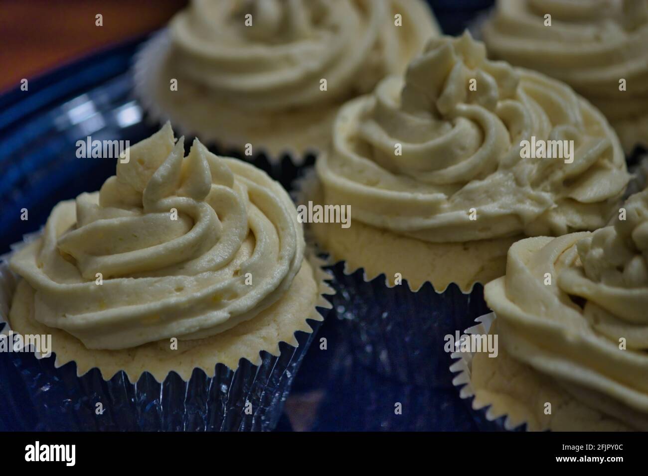 lemon flavored icing piped over the top of a vanilla cupcake Stock ...