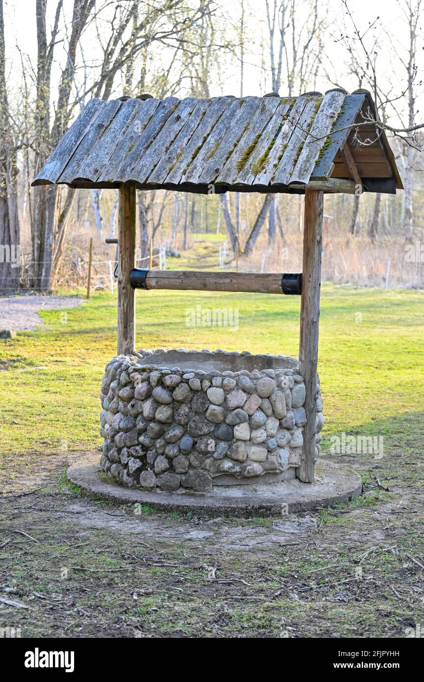 old water well with roof standing in garden Stock Photo - Alamy