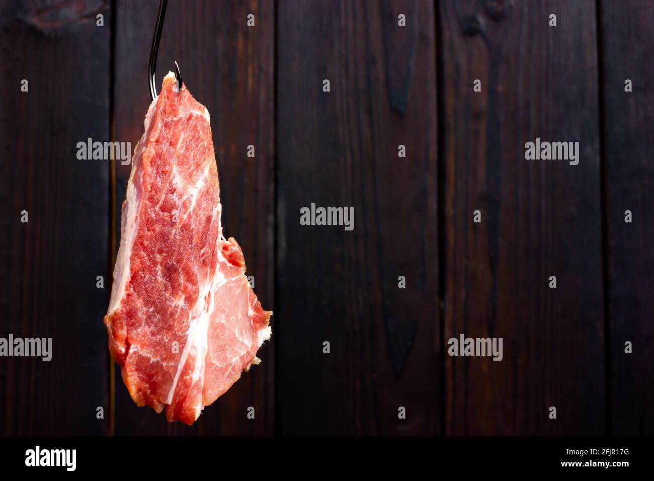 Pork steak hung on a hook. Raw meat. Counter in a butcher shop Stock ...