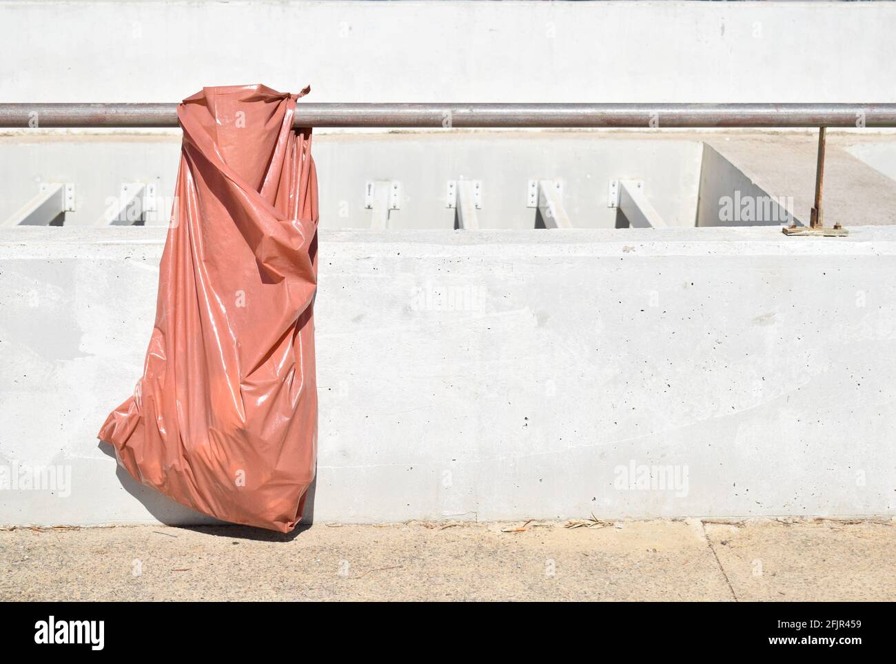 Large plastic trash bag on a concrete wall railing Stock Photo - Alamy