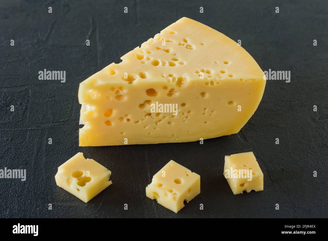 Radamer cheese on a black concrete background. triangular piece of ...