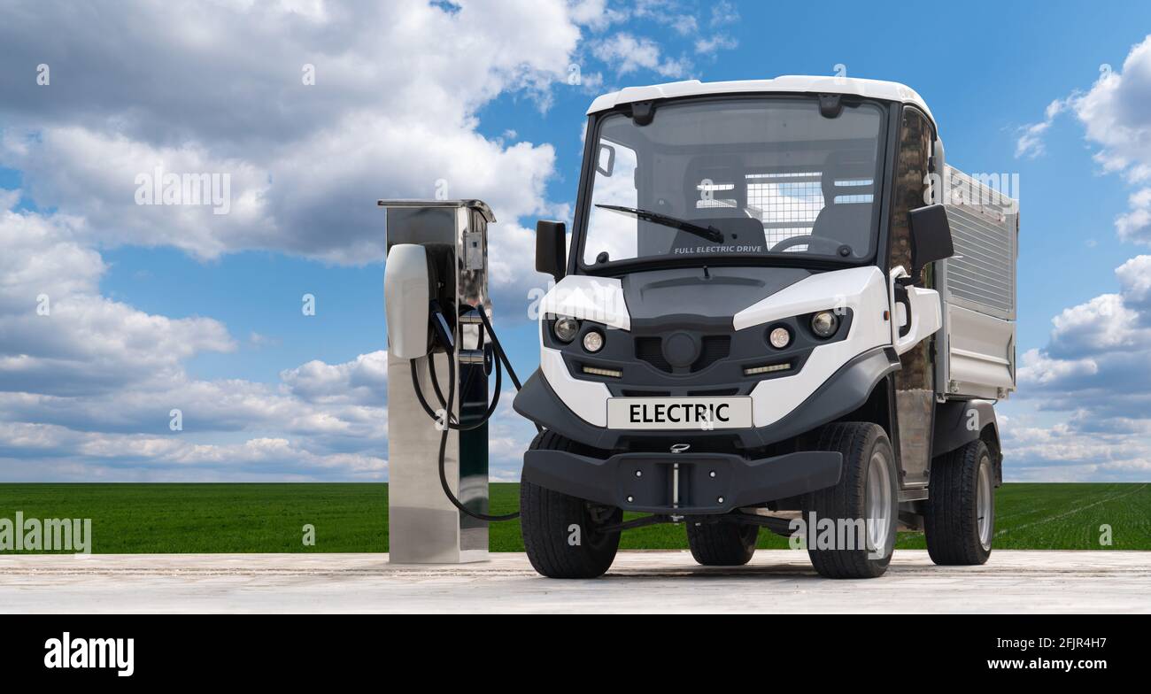 City delivery electric truck with charging station on a background of ...