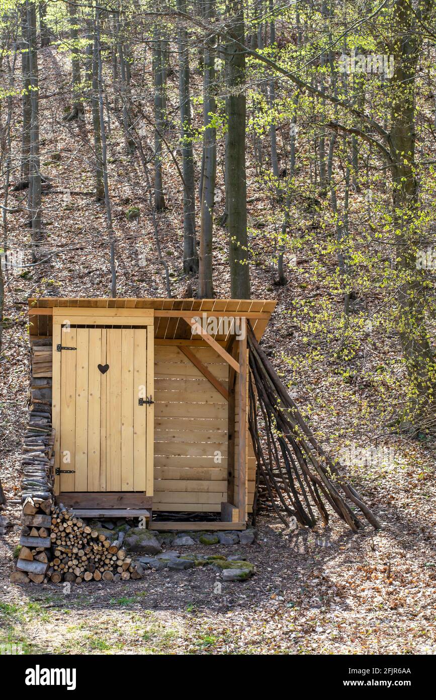 Rustic wooden toilet in the forest with a heart-shaped hole in the door ...