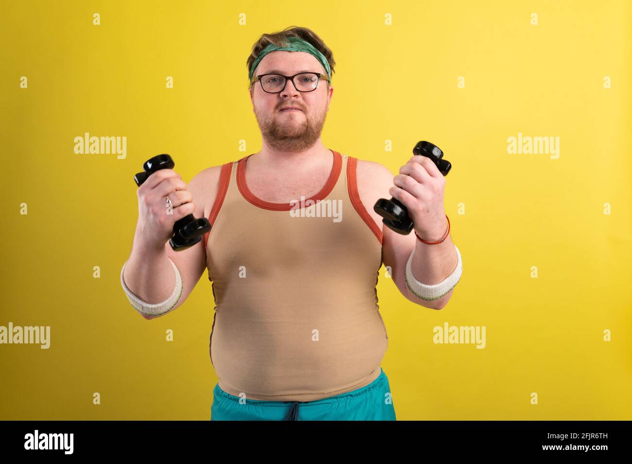 funny fat man doing exercises with dumbbells. Overweight. yellow ...