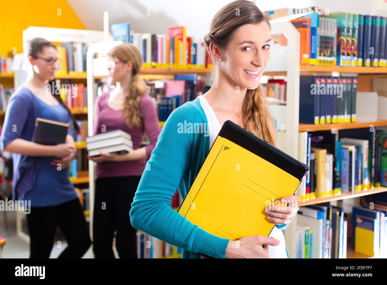 Student - young woman or girl with books in library learning Stock ...
