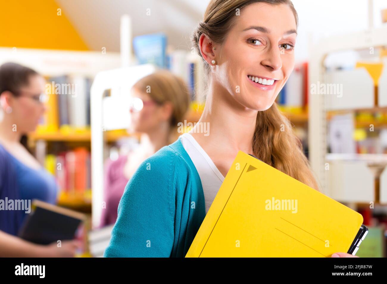 Student - young woman or girl with books in library learning Stock ...