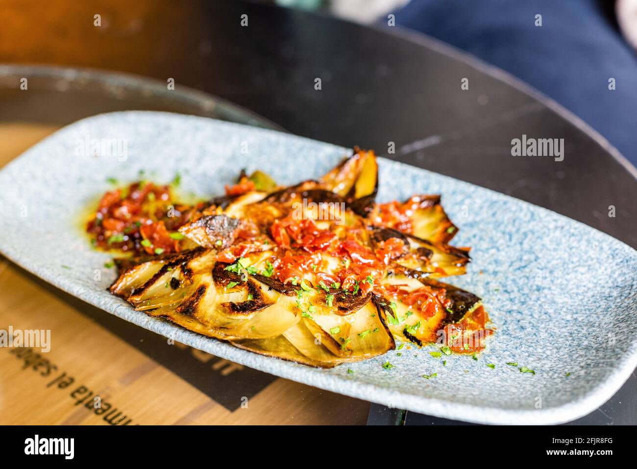 Delicious tapa of artichokes with ham and fried onion in a bar in ...