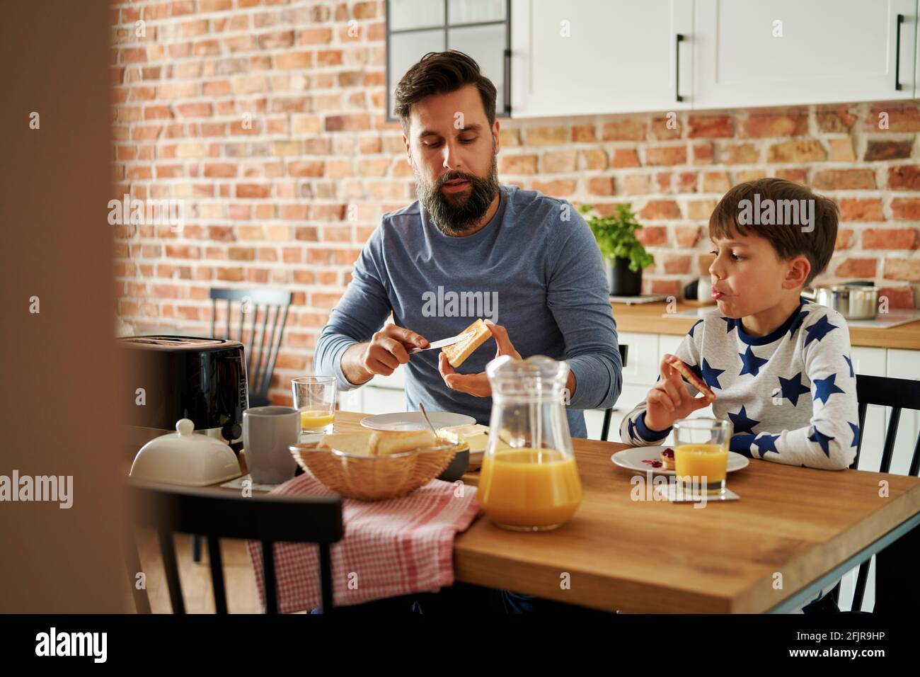 Father and son eating breakfast together at the morning Stock Photo - Alamy