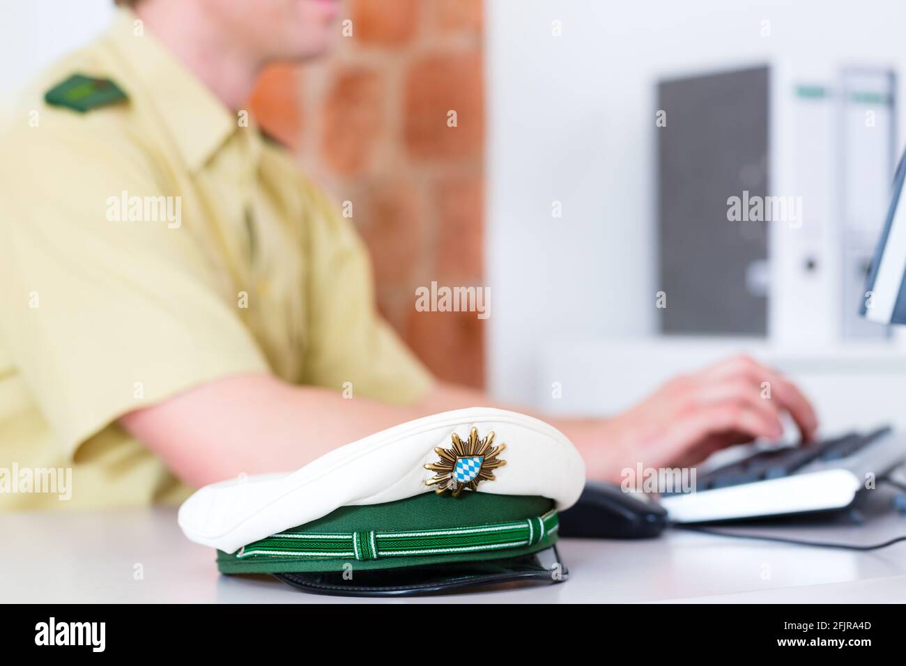 Police officer in police station working on the computer, on a case or ...