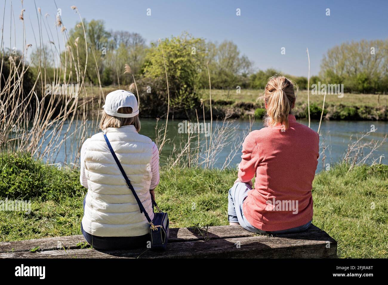 Two women rest beside a reservoir during a woodland walk in Oxfordshire ...